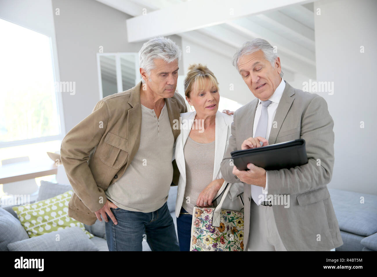Senior couple with real-estate agent visiting house for sale Stock ...
