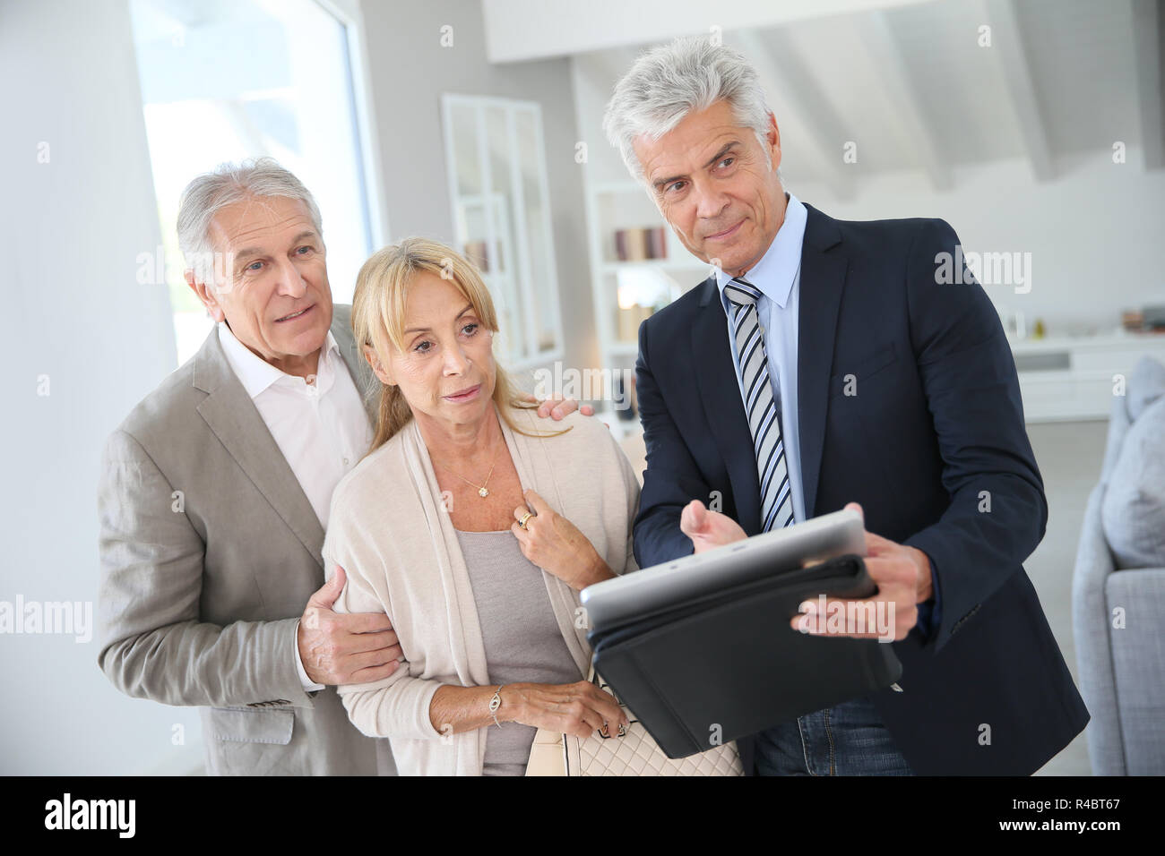 Senior couple with real-estate agent visiting house for sale Stock ...