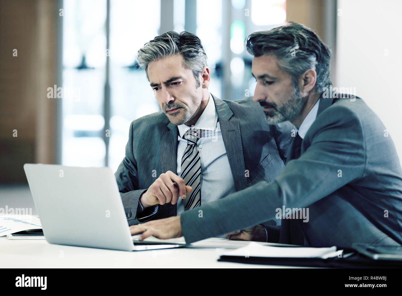 Businessmen working on laptop computer Stock Photo - Alamy