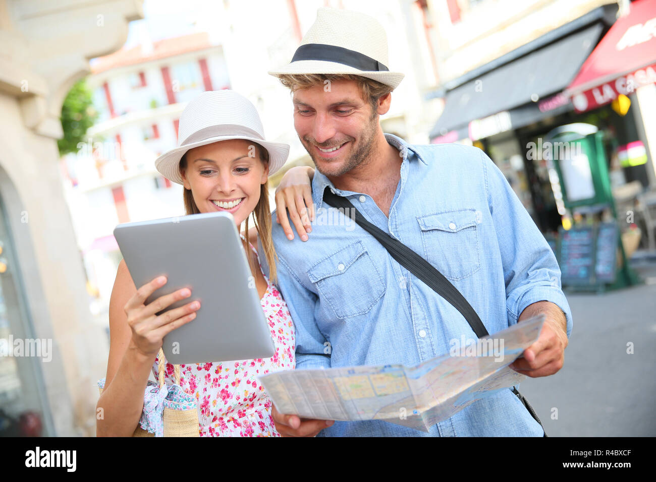 Couple in vacation looking at tourist guide on internet Stock Photo - Alamy