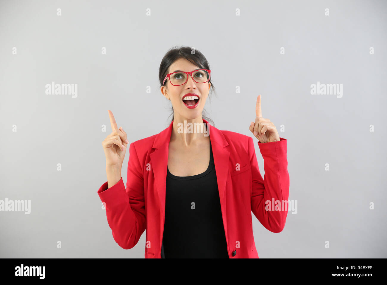 Beautiful brunette girl with red jacket pointing at message Stock Photo ...