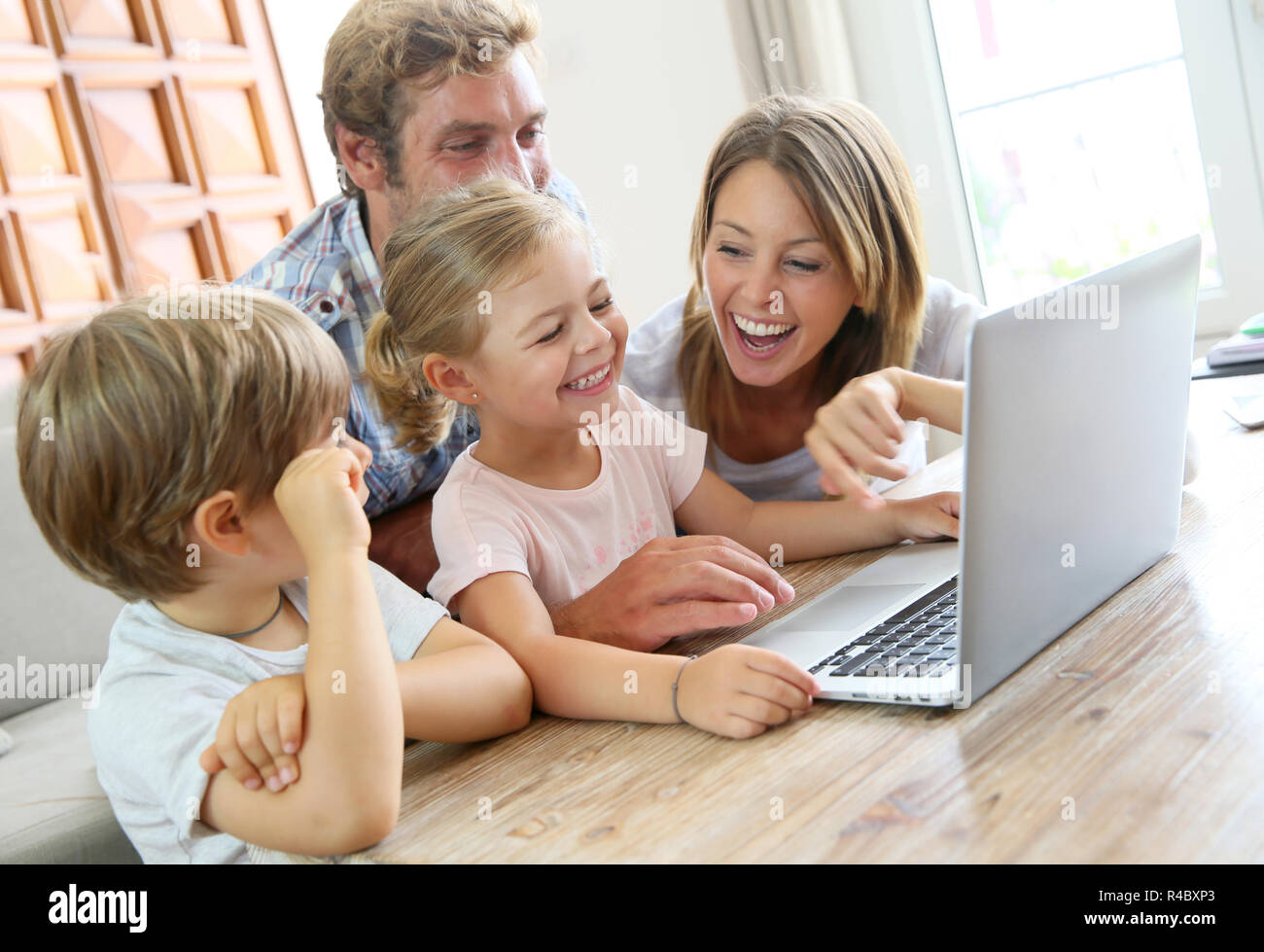 Parents with kids at home using laptop computer Stock Photo - Alamy