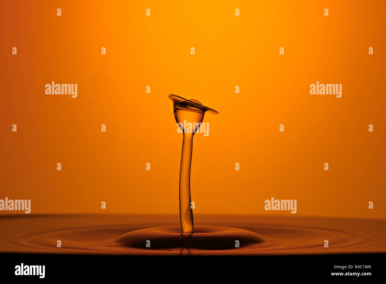 Water Drop Collision Macro, Amber Background Stock Photo - Alamy