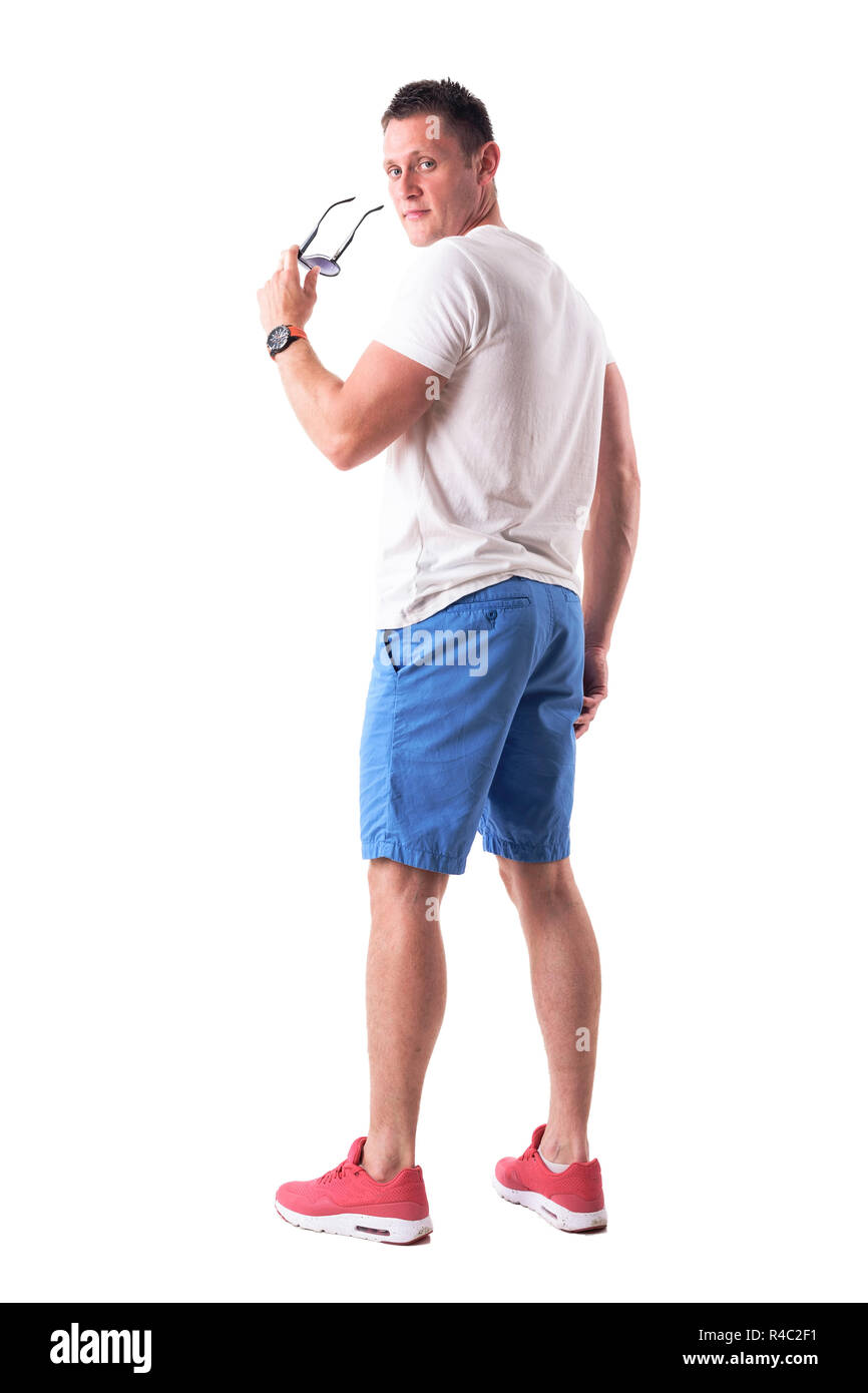 Confident fashion model in summer clothes holding sunglasses and ...