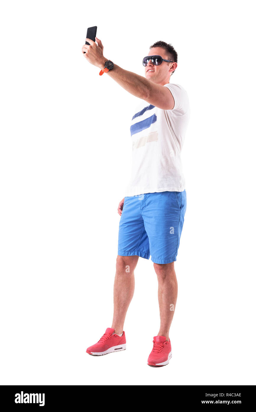 Happy smiling man tourist in summer clothes taking high angle selfie ...