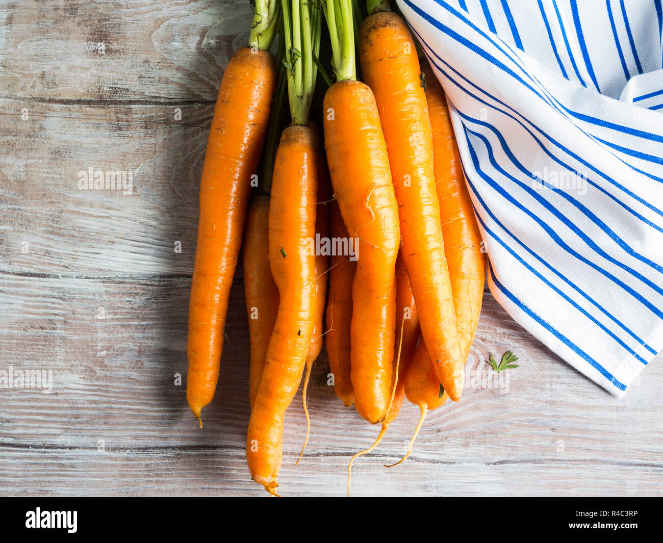 Raw carrots on rustic wooden background. Cooking vegetables Stock Photo ...