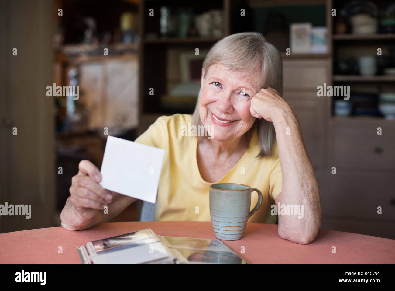 Woman looking through photos in picture album Stock Photo - Alamy