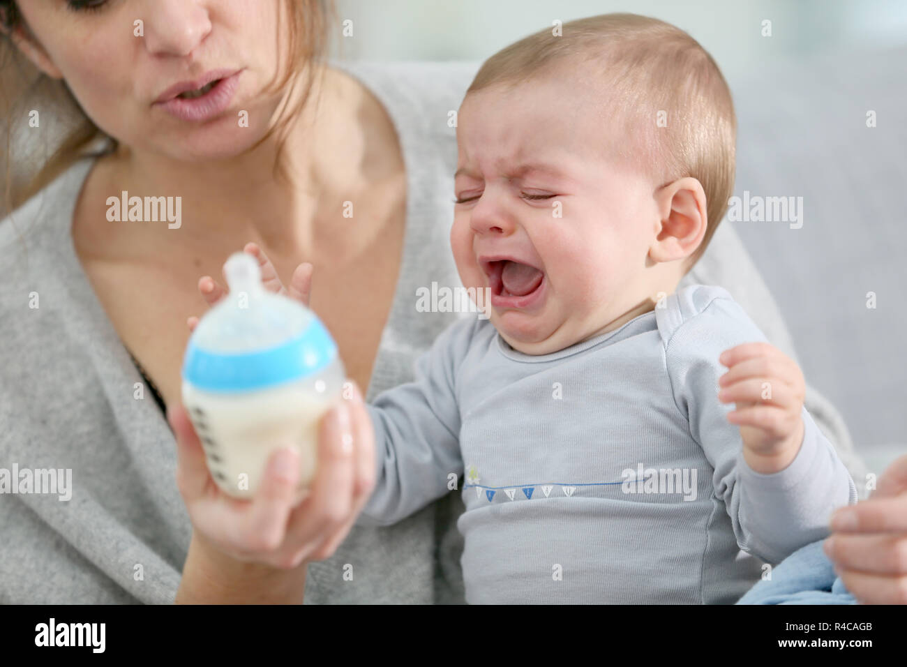 Crying baby bottle feeding hi-res stock photography and images - Alamy