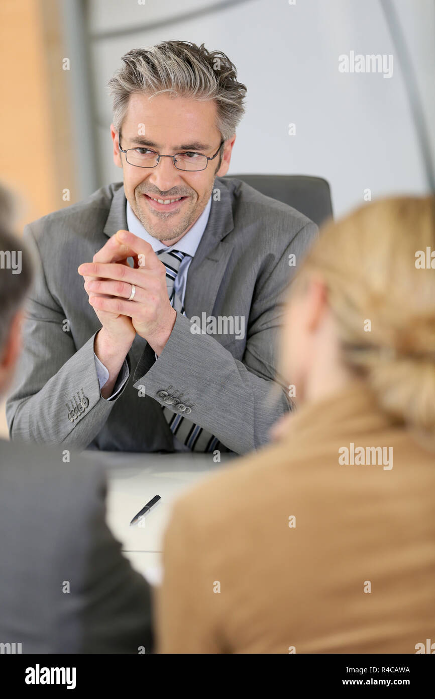 Consultant listening to clients in meeting Stock Photo - Alamy