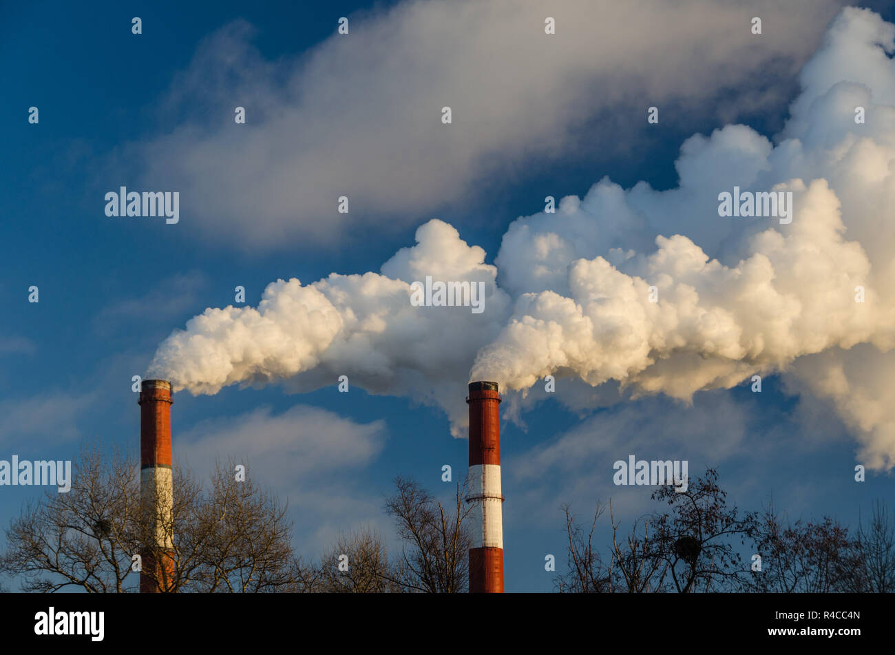 Smoking pipes making clouds against blue sky background Stock Photo - Alamy