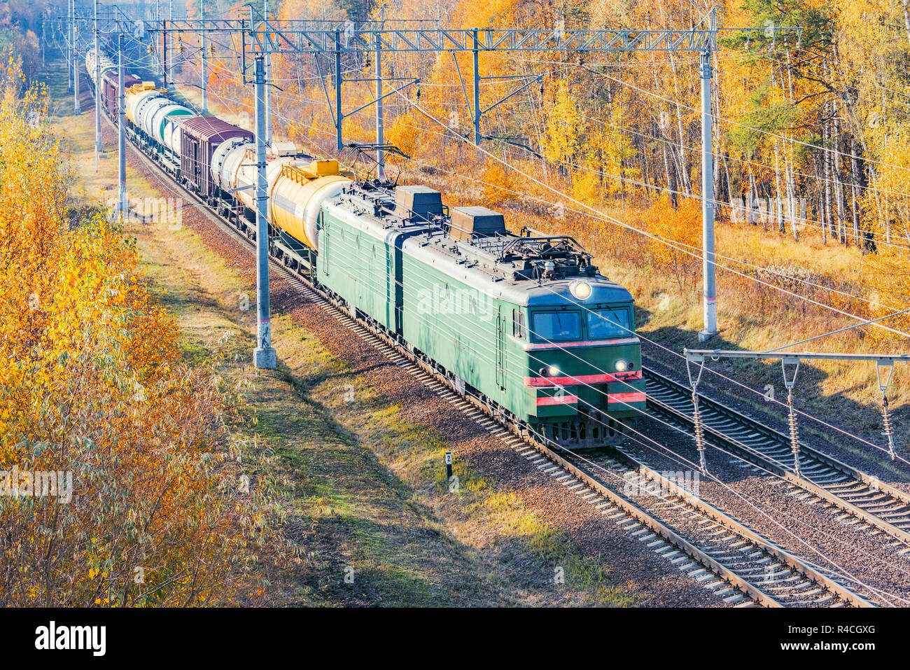 Long freight train approaches to the station at autumn day time Stock ...