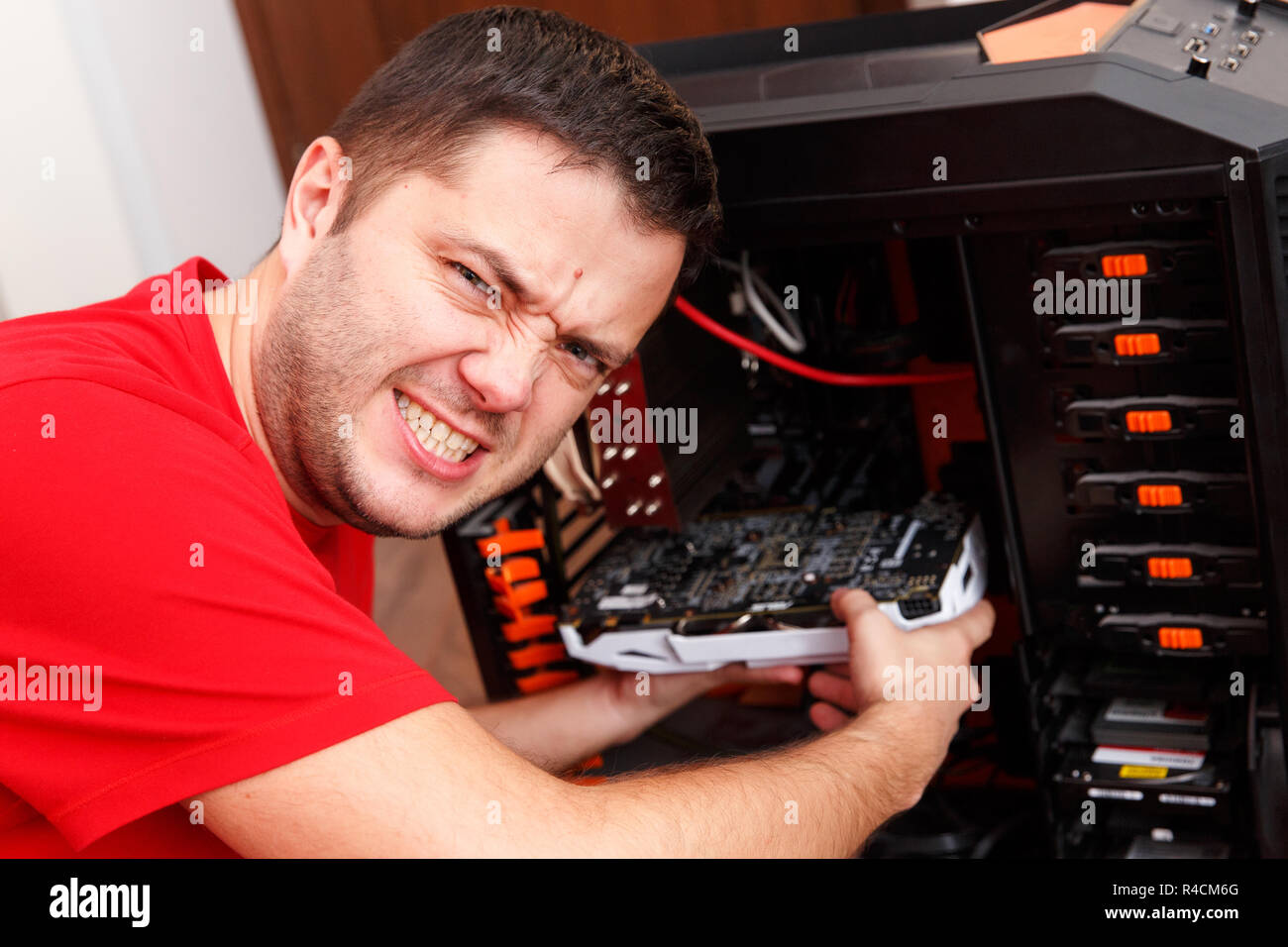 Image of angry man mending processor while in apartment Stock Photo - Alamy