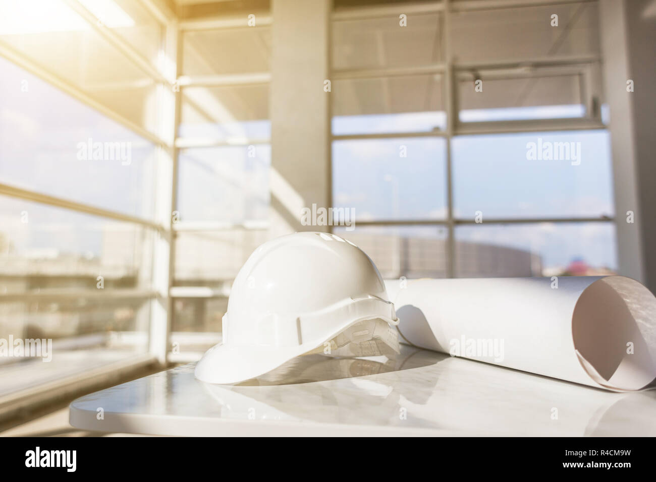 white helmet, blueprints of a building on a construction site on a ...