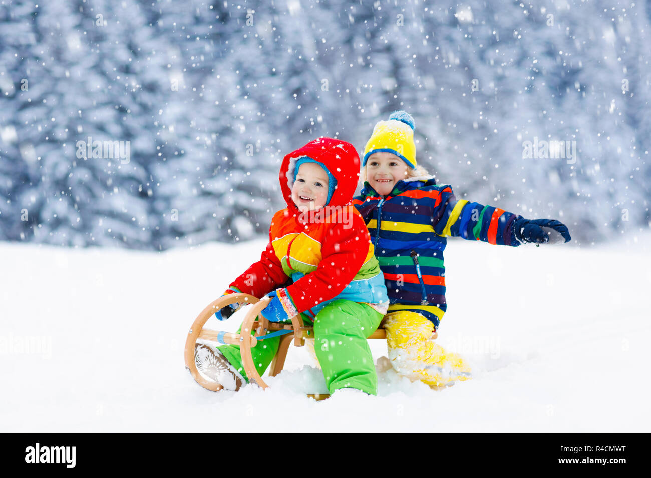 Little girl and boy enjoying sleigh ride. Child sledding. Toddler kid ...