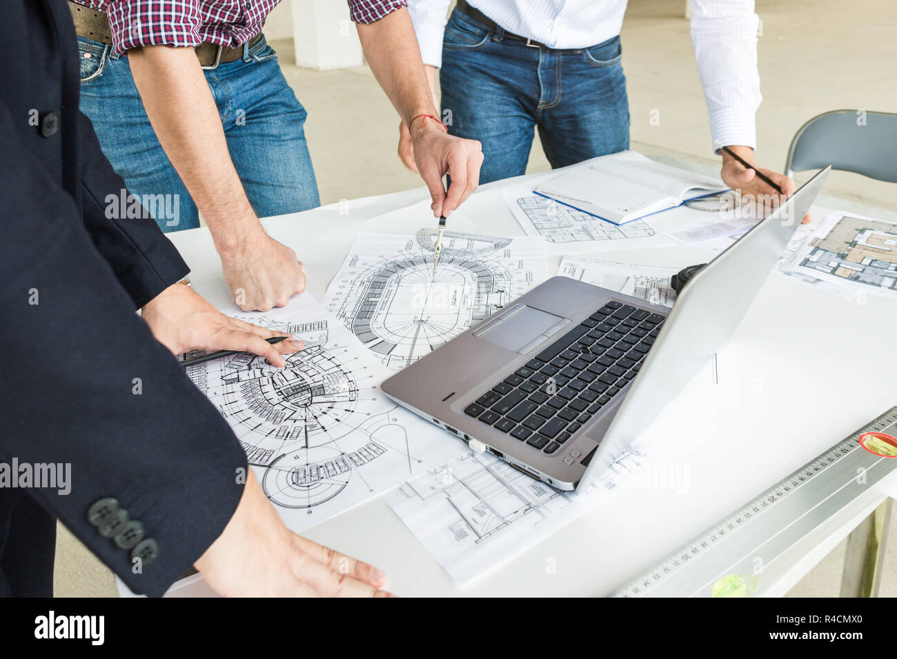 male engineers, architects working at the desk in helmets. Drawings ...