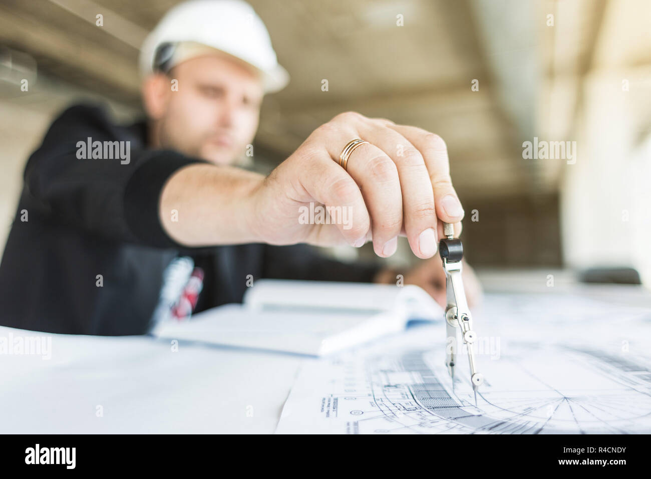 architect builder works at the table with drawings. Helmet, drawings ...