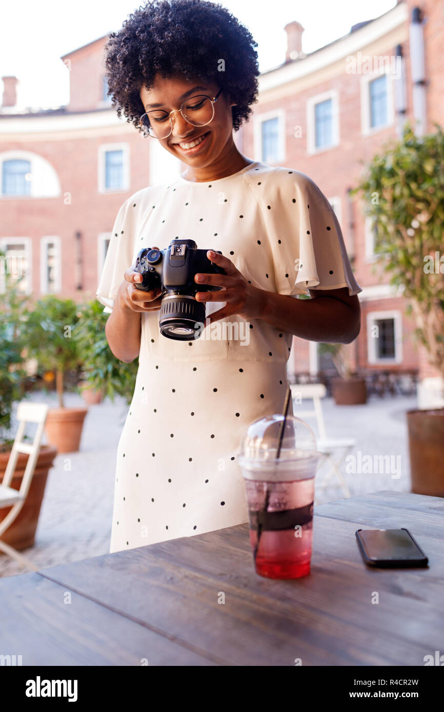 Smiling girl looking on screen of a dslr camera Stock Photo - Alamy