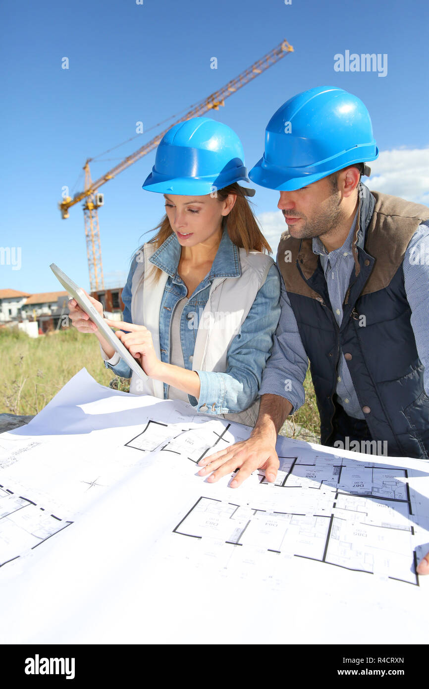 Construction people looking at blueprint Stock Photo - Alamy