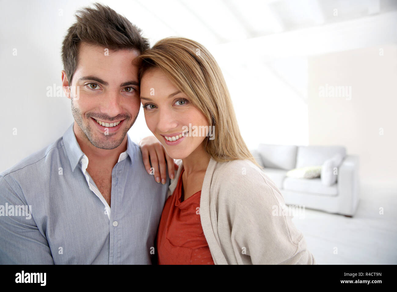 Couple standing in contemporary home Stock Photo - Alamy