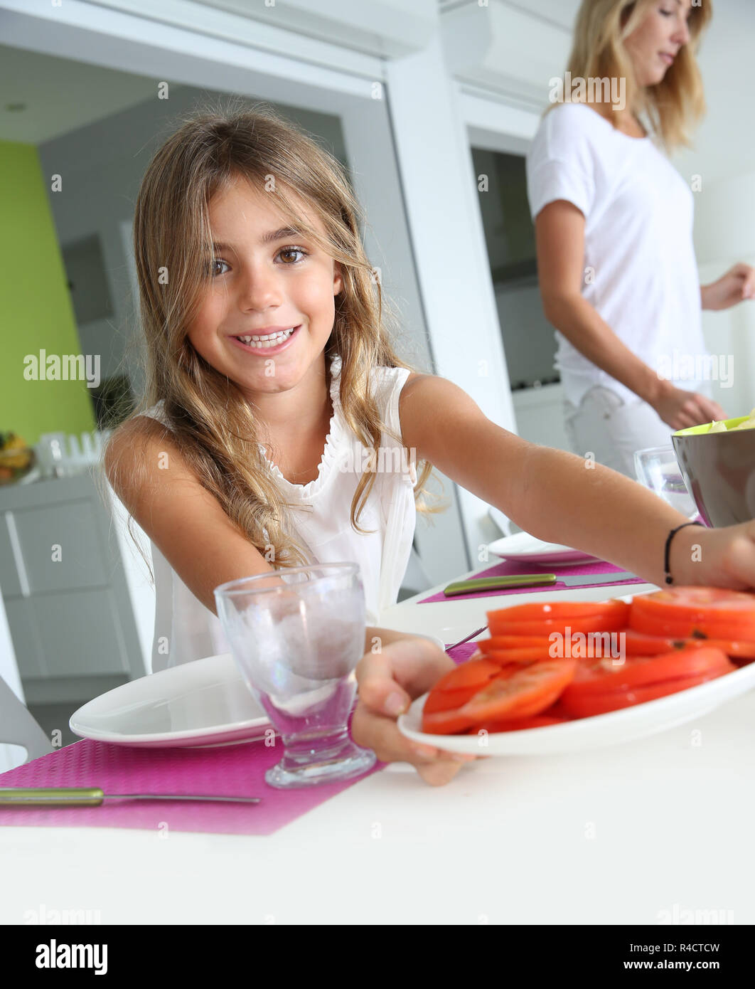 Little girl helping putting the table up for lunch Stock Photo - Alamy