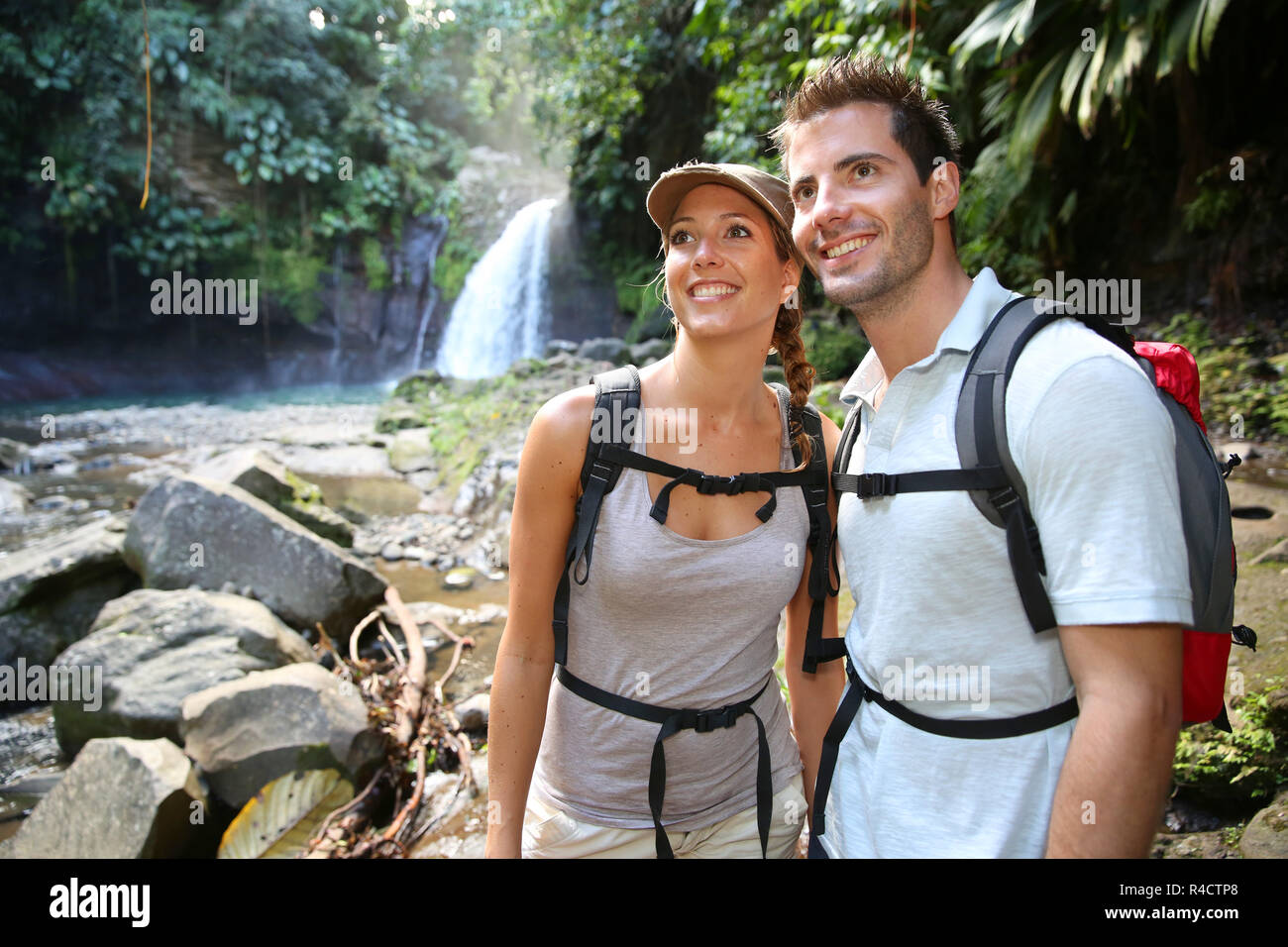 Trekkers reaching waterfall in natural landscape Stock Photo - Alamy