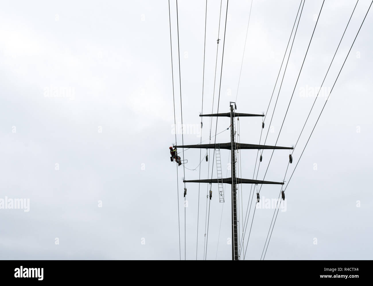 Working professional men on high voltage power lines high up on lattice ...