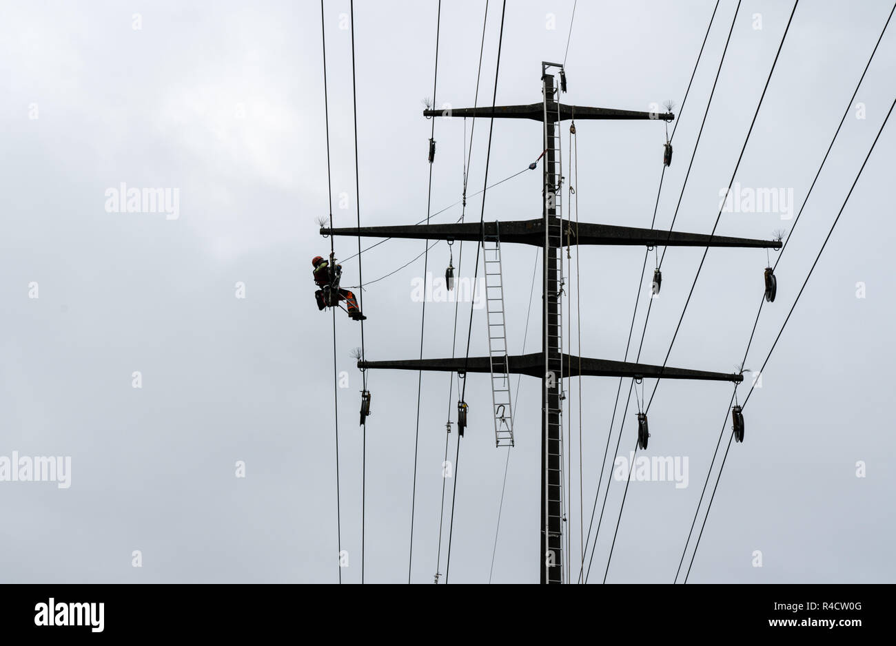 Working professional men on high voltage power lines high up on lattice ...