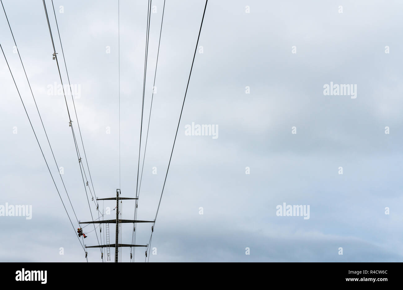 Working professional men on high voltage power lines high up on lattice ...