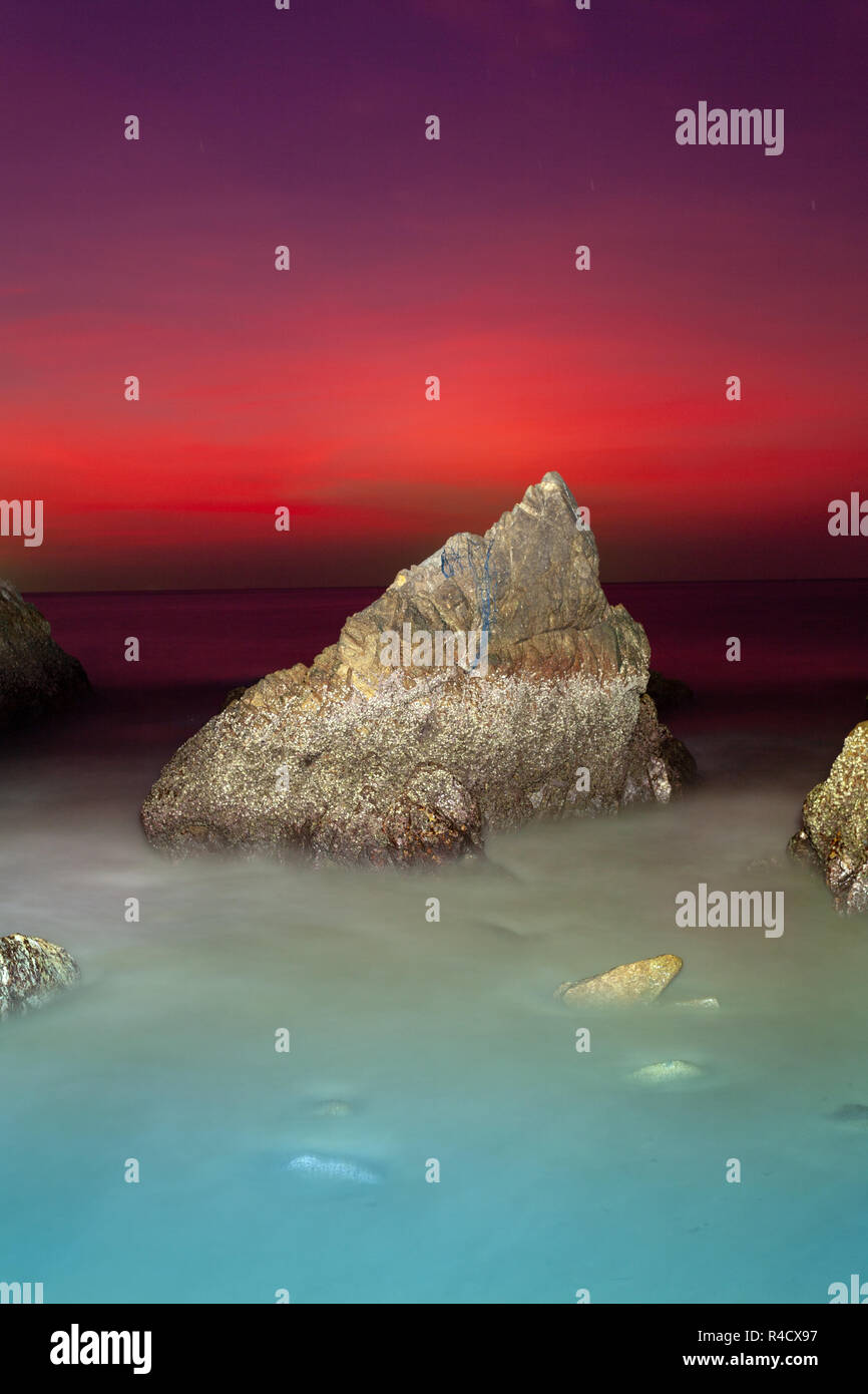 waves hit the big cone shape rock in the middle of stone cape during ...