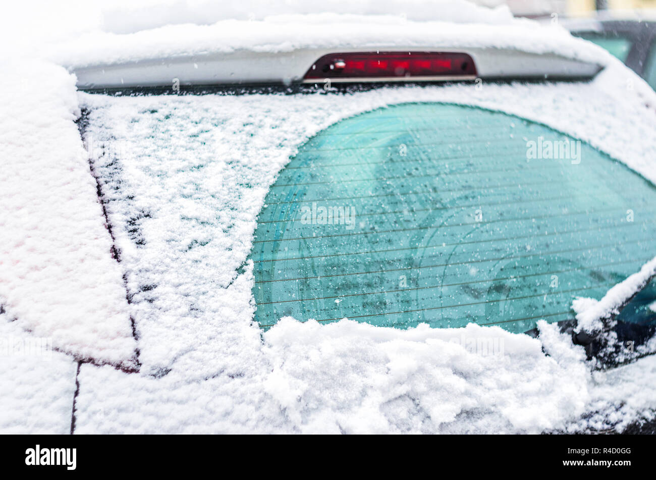 Wipers sweep snow from the rear window of the car. Concept: winter ...