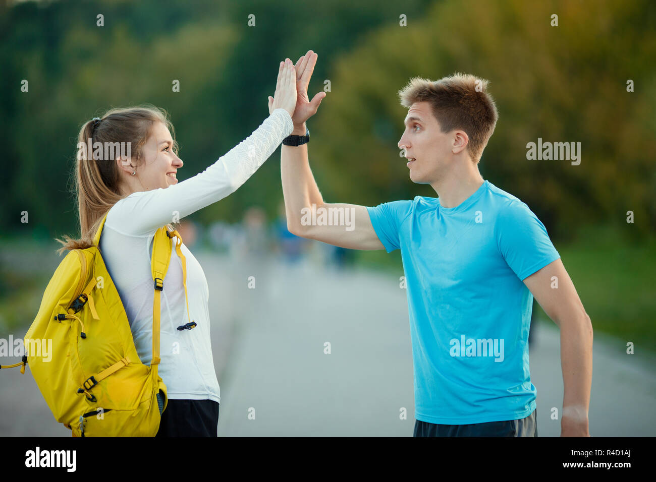 Picture of young women and men doing handshake in park on summer day ...