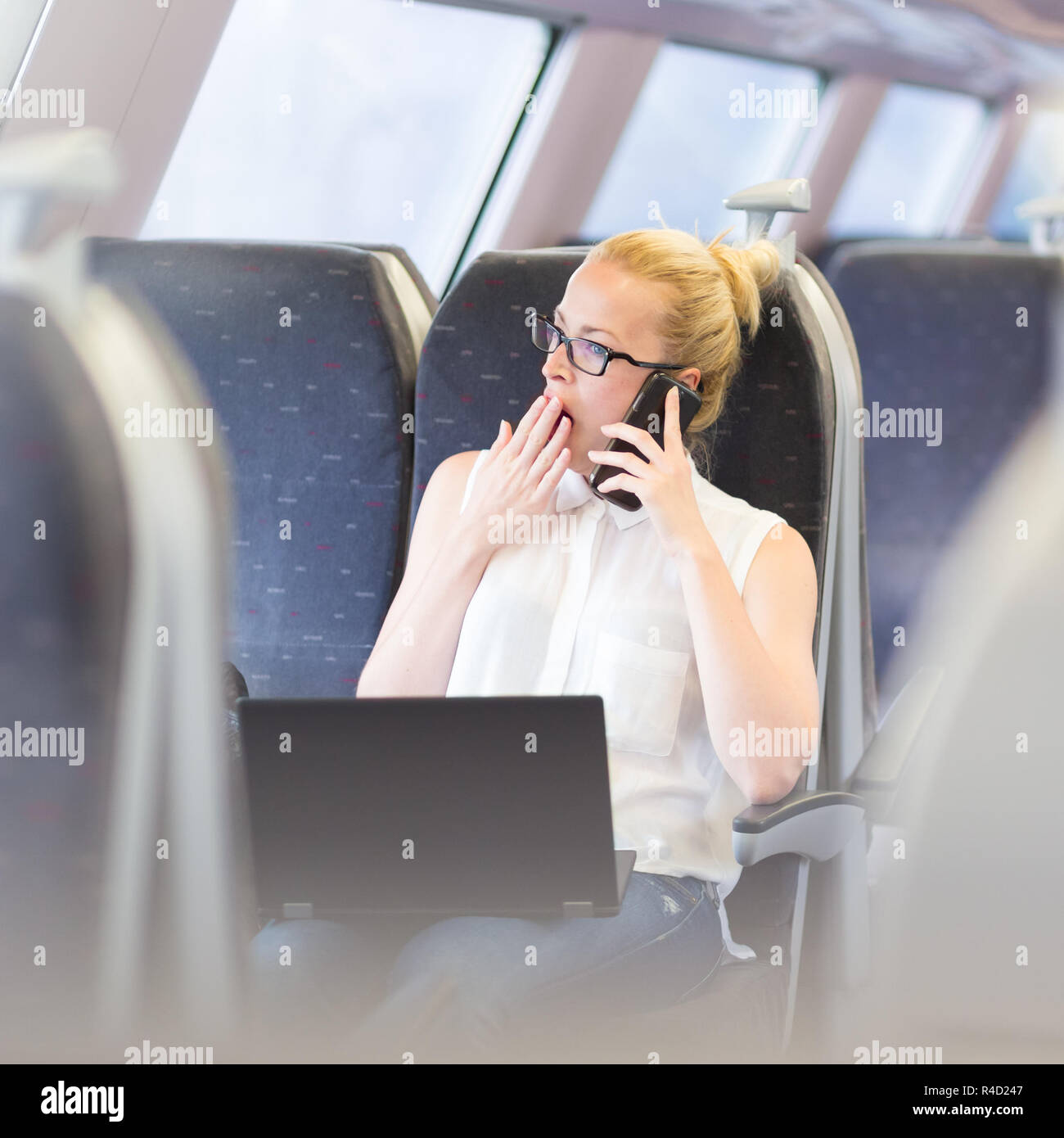 Business woman working while travelling by train Stock Photo - Alamy