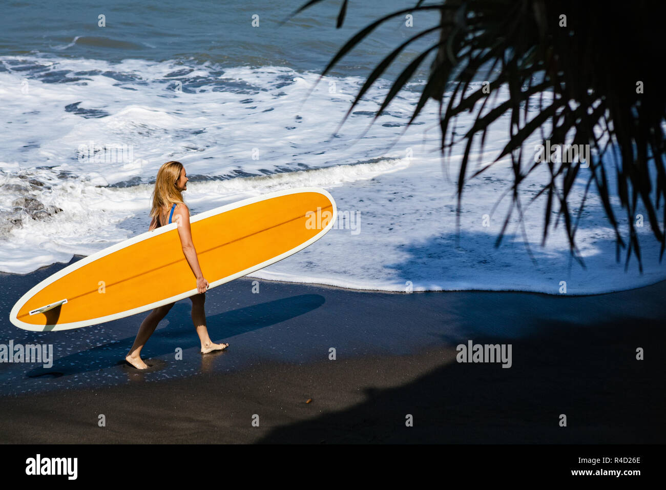 Sporty Girl In Bikini With Surf Board Walk On Black Sand Beach Young