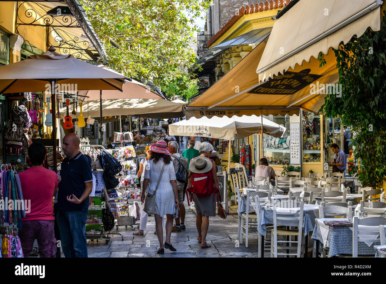 Tourists walk the narrow path between souvenir shops and outdoor ...