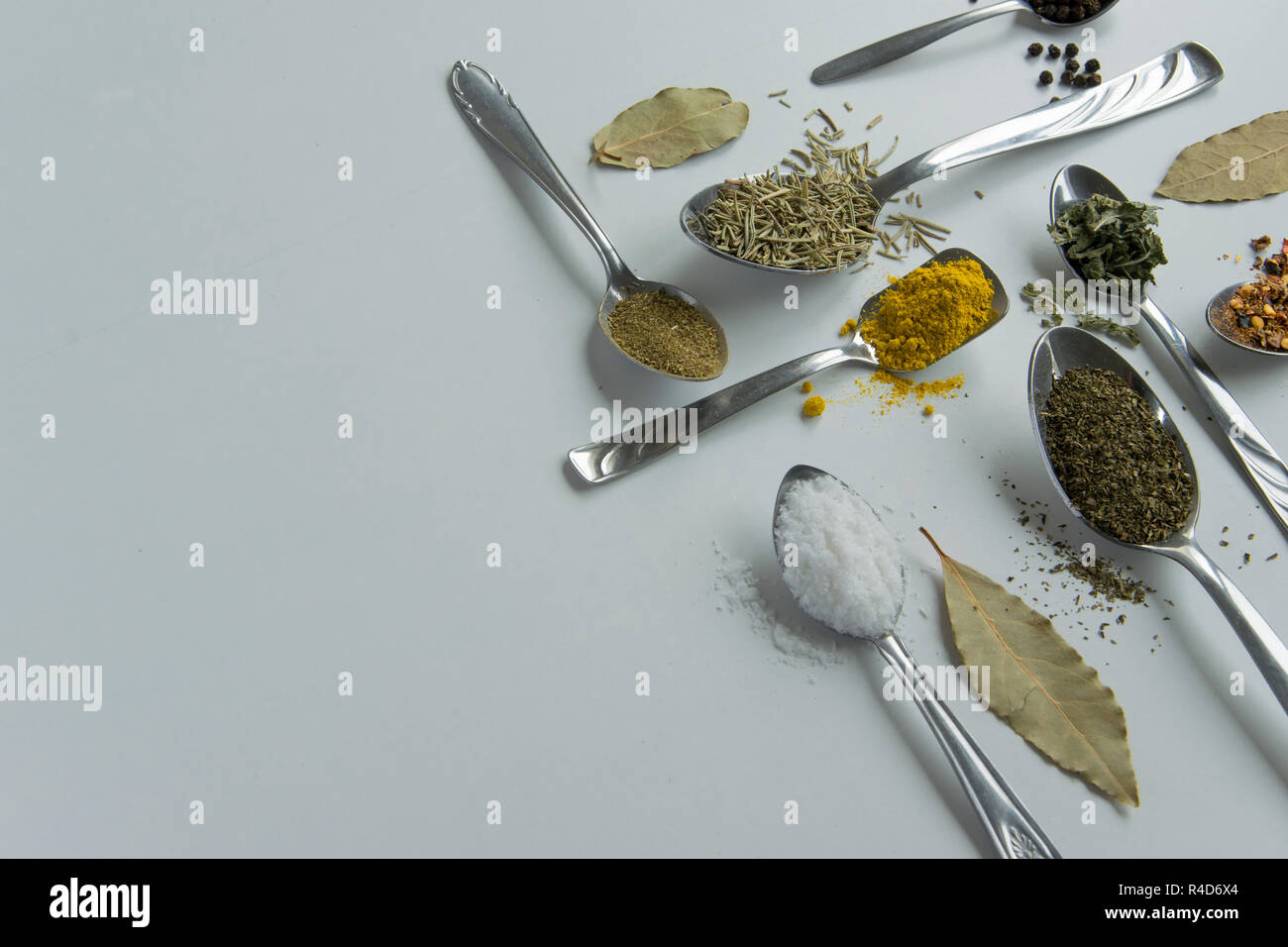 Spoons with various aromatic herbs and spices on white background ...