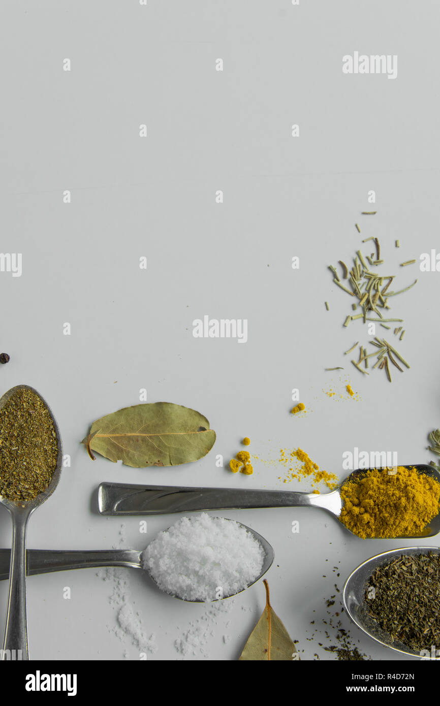 Spoons with various aromatic herbs and spices on white background ...