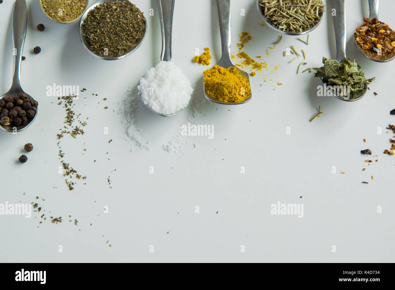 Spoons with various aromatic herbs and spices on white background ...