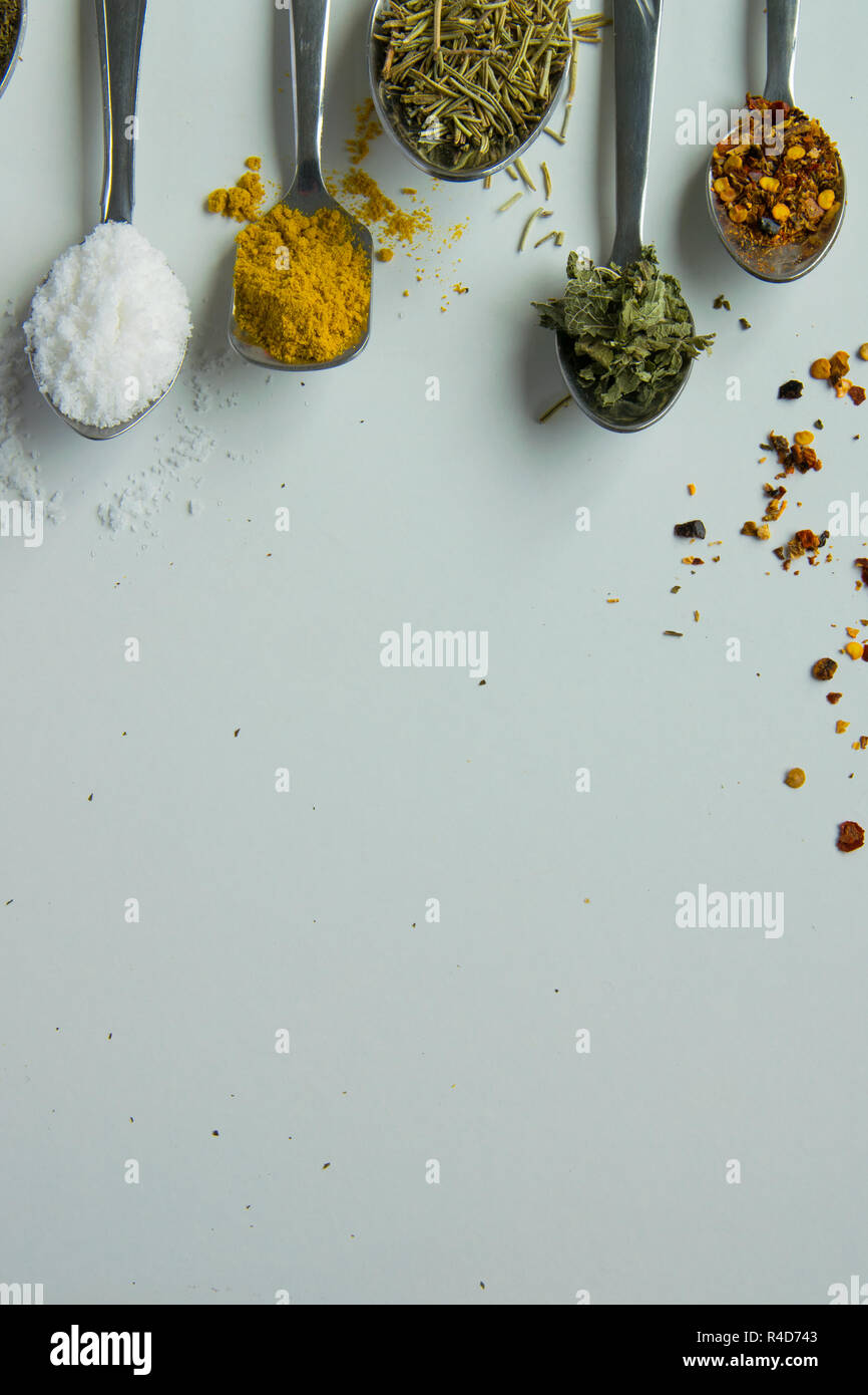 Spoons with various aromatic herbs and spices on white background ...