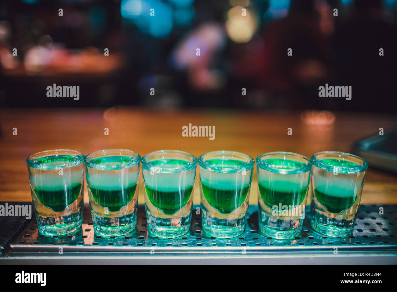 Green liquid in shot glasses standing on the counter Stock Photo - Alamy