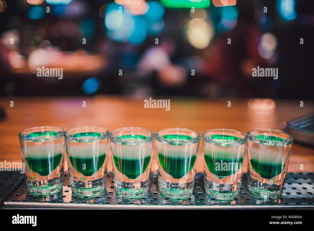 Green liquid in shot glasses standing on the counter Stock Photo - Alamy