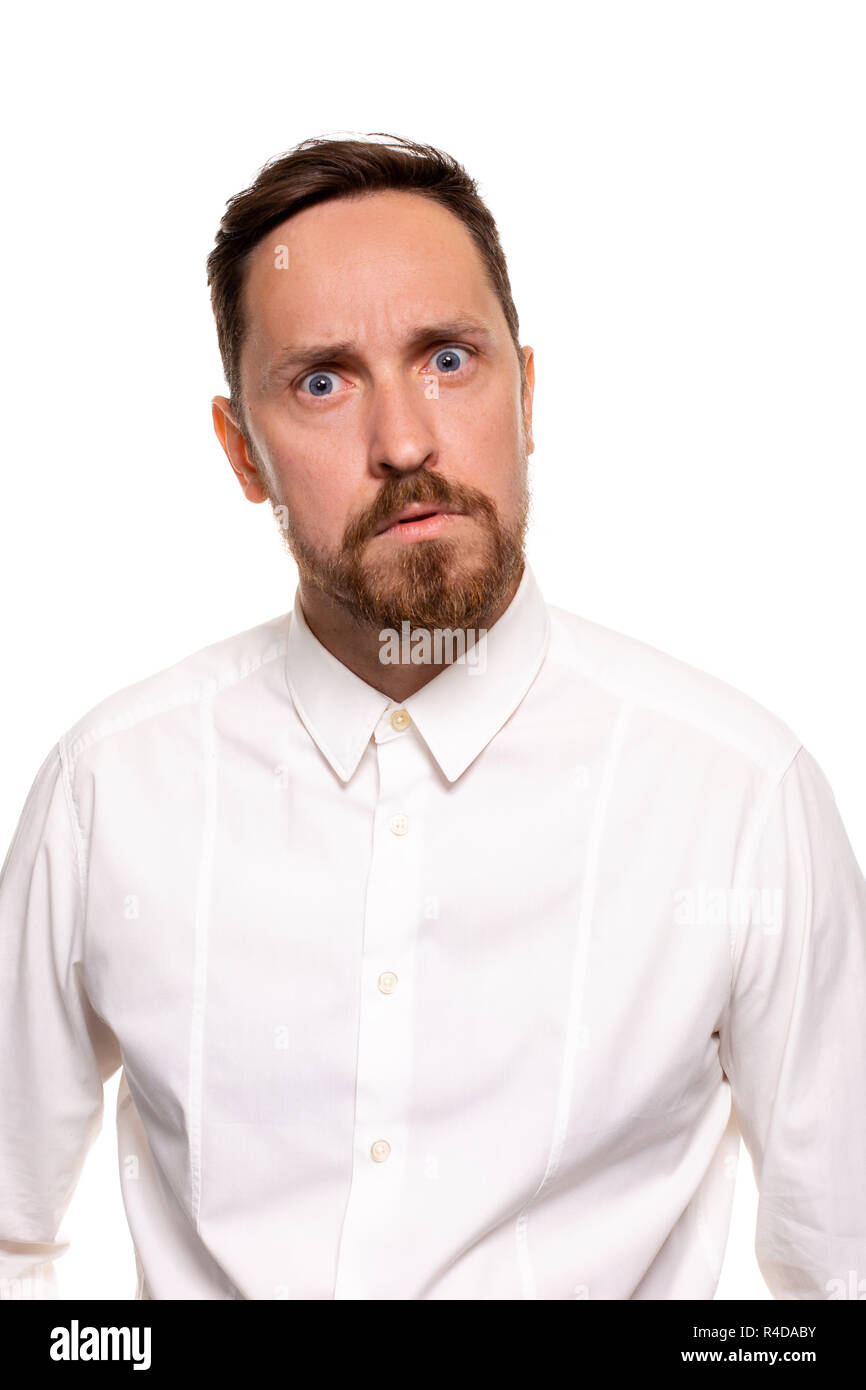 Portrait of handsome man with stubble has indignant expression, frowns ...