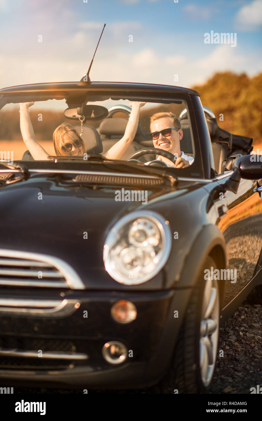 amorous couple in the car is happy and arms outstretched Stock Photo ...