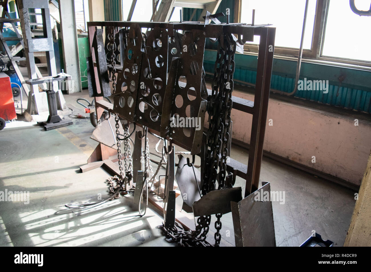 Chains and auxiliary metal tools in the forge’s industrial workshop ...