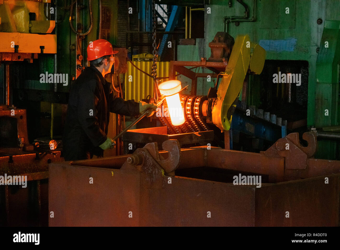 Hot iron in smeltery held by a worker. High precision hot forging ...