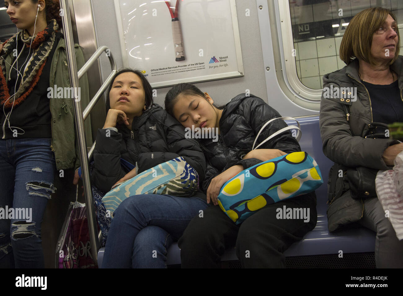 A set of tired young twins ride a subway train in Manhattan, New York ...