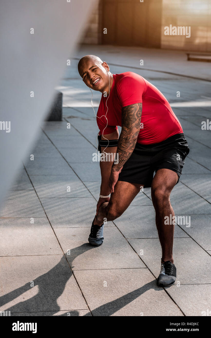 Cheerless nice young man twisting his ankle Stock Photo - Alamy