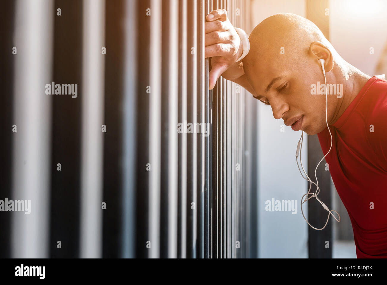 Sad tired man standing in his headphones Stock Photo - Alamy