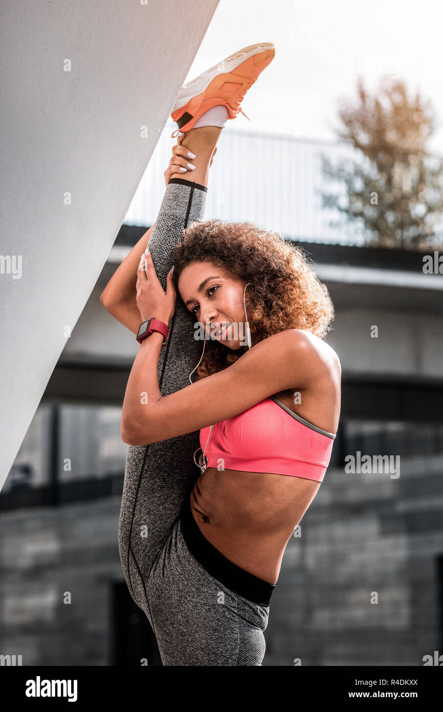 Serious beautiful woman doing a stretching exercise Stock Photo - Alamy