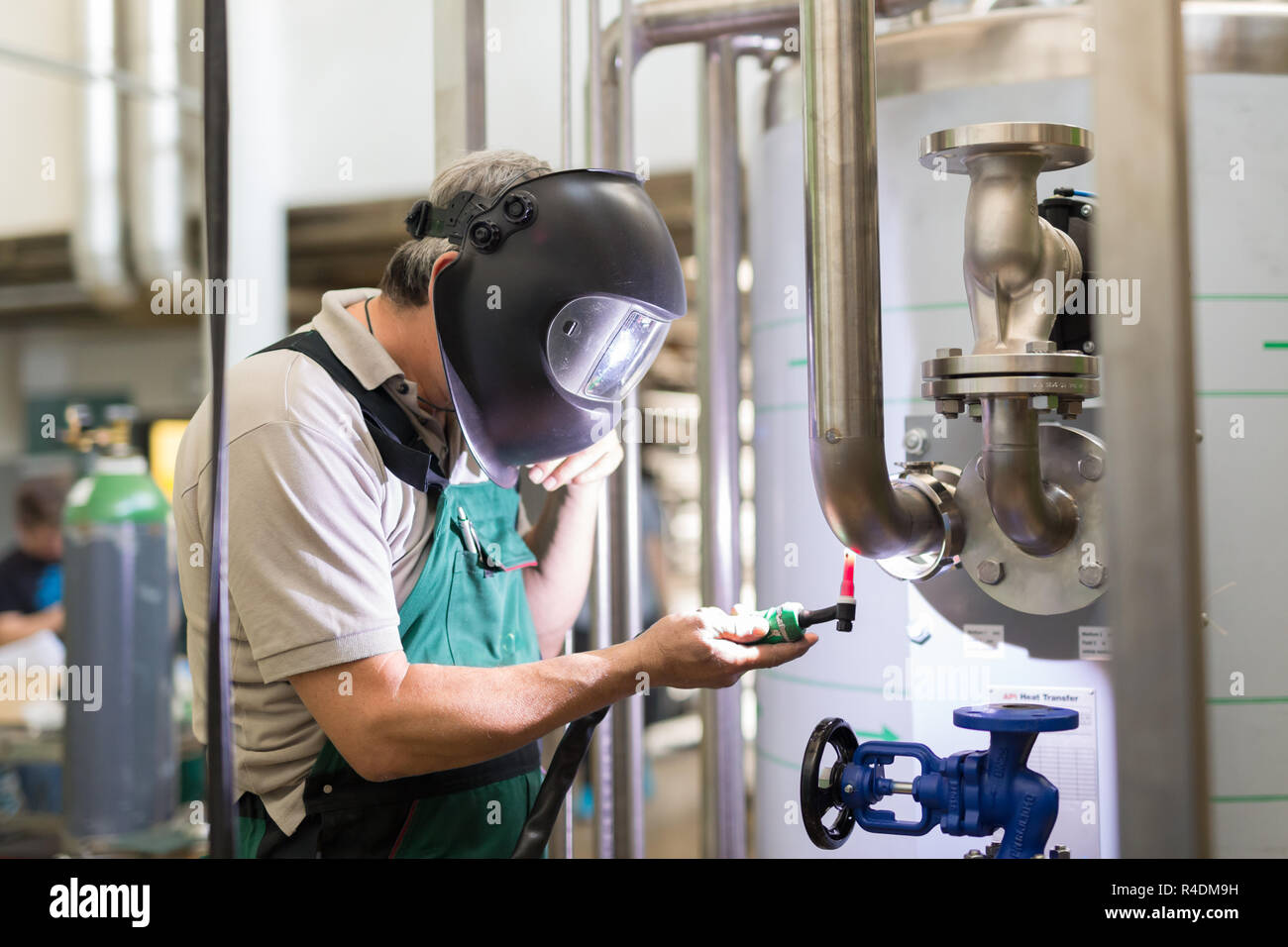 Industrial worker welding in metal factory Stock Photo - Alamy