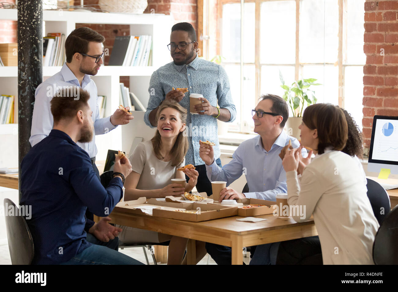 Multiracial work team eating pizza together on break Stock Photo - Alamy
